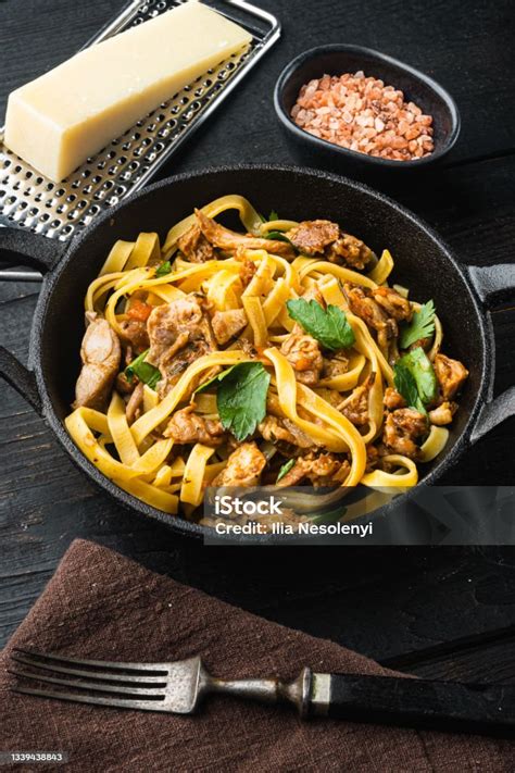 파스타 타글리아텔 또는 파파르델레를 곁들인 맛있는 매운 토끼 스튜 주철 팬이나 냄비에 검은 나무 테이블에 타그리아텔리에 대한 스톡 사진 및 기타 이미지 Istock