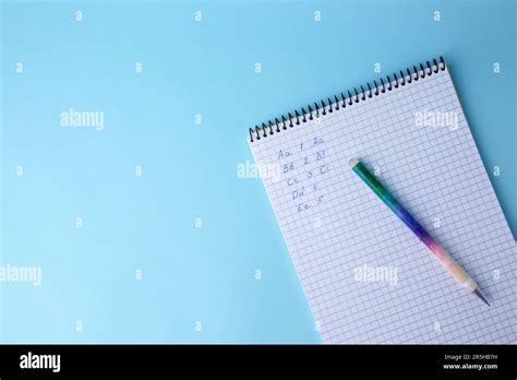 Letters And Numbers Written In Notepad With Erasable Pen On Light Blue Background Top View