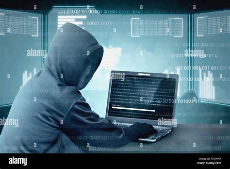 Hacker In Black Hoodie Using Laptop On The Desk To Hacking System With