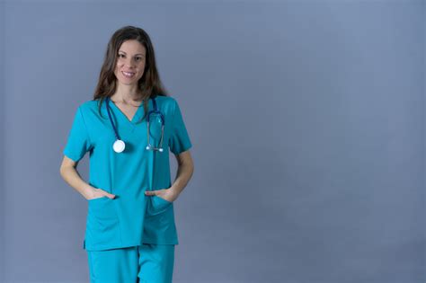 청진기를 가진 의사가 평평한 배경에서 주머니에 손을 넣고 웃는 여자를 들여다 보며 30 34세에 대한 스톡 사진 및 기타 이미지 30 34세 건강관리와 의술 미소