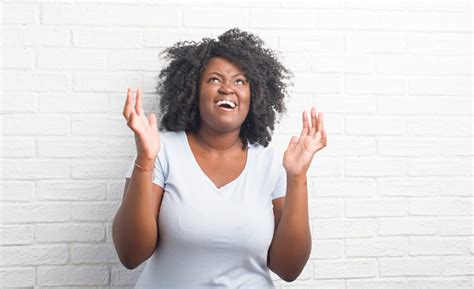 젊은 아프리카계 미국인 플러스 크기 여자 흰 벽돌에 벽 미친 미친 소리 하 고 적극적인 식와 팔 발생 함 좌절 개념입니다 감정에