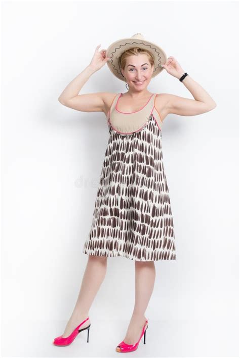 Bella Ragazza Esile In Un Vestito Variopinto In Un Cappello Da Cowbabe E Nelle Scarpe Rosse Su