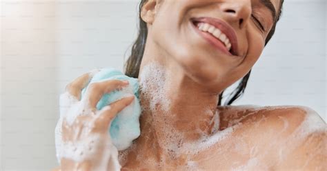 각질 제거 스폰지로 몸을 씻는 그녀의 피부에 거품이 있는 웃는 여인의 클로즈업 사진 Unsplash의 기쁨 이미지