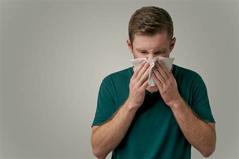 건강 하지 못한 사람 나쁜 느낌 녹색 T셔츠에 사람이 그의 코를 불고 하 고 손수건에 재채기 스튜디오에서 회색 배경에 절연 건강관리와 의술에 대한 스톡 사진 및 기타 이미지