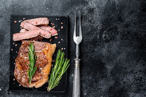 구운 뉴욕 스트립 쇠고기 고기 스테이크 또는 스트립을 대리석 보드에 자른다 검은 색 배경 맨 위 보기입니다 복사 공간 0명에 대한 스톡 사진 및 기타 이미지 Istock