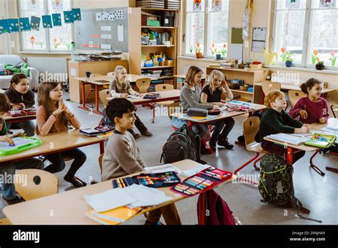 Male And Female Students Attending Lecture In Classroom At School Stock