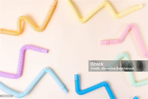 트렌디 한 어린이 장난감 파스텔 베이지 색 배경에 다채로운 팝 튜브 형태와 색상의 집합 골판지 파이프 및 안티 스트레스 휴식 Fidget 손가락 장난감 스트레칭에 대한 스톡