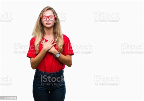 젊은 아름 다운 금발 여자 닫힌 된 눈과 얼굴에 감사 제스처와 가슴에 손으로 웃 고 고립 된 배경 위에 안경을 착용 건강 개념입니다 감사에 대한 스톡 사진 및 기타 이미지