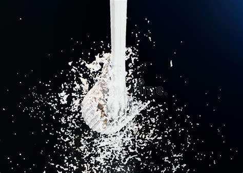 White Liquid Stream Falling Into A Puddle Of Water In The Middle Of A Picture Stock Image
