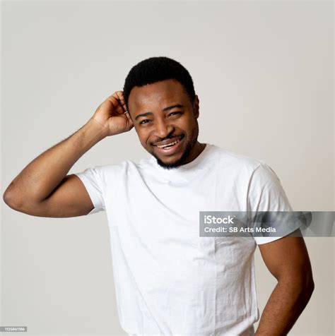 포즈와 카메라 보고 아름 다운 미소로 유혹 하는 행복 한 얼굴로 매력적인 부끄러워 젊은 아프리카계 미국인 남자의 반 길이 초상화 긍정적인 감정을 사람과 인간의 얼굴 표정