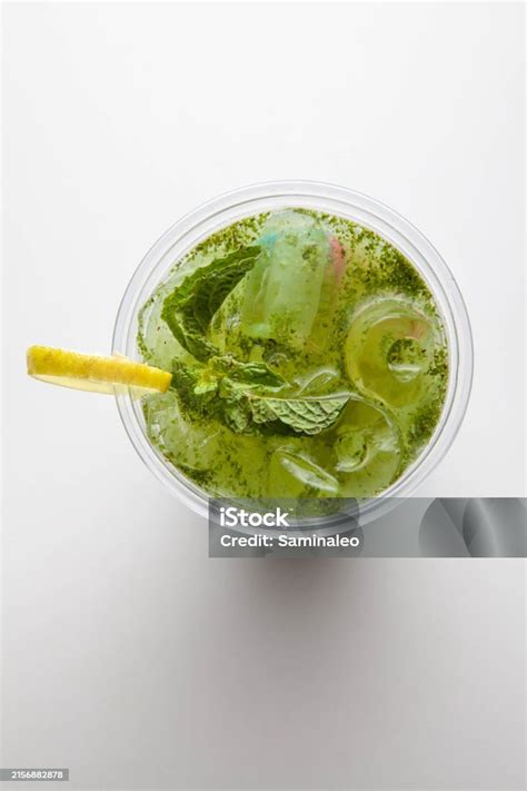 민트 레모네이드 Shikanjabeen은 흰색 배경의 상단 조감도에 민트 잎 얼음 조각 및 레몬 조각과 함께 플라스틱 투 고 컵에 제공됩니다 0명에 대한 스톡 사진 및 기타