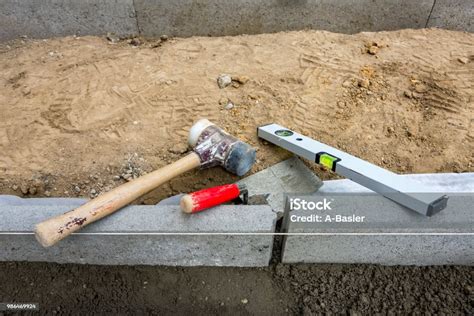콘크리트와 수준 및 망치에 가장자리 테두리 돌으로 지지대를 설정 건설 현장에 대한 스톡 사진 및 기타 이미지 건설 현장 흙손 가장자리 Istock