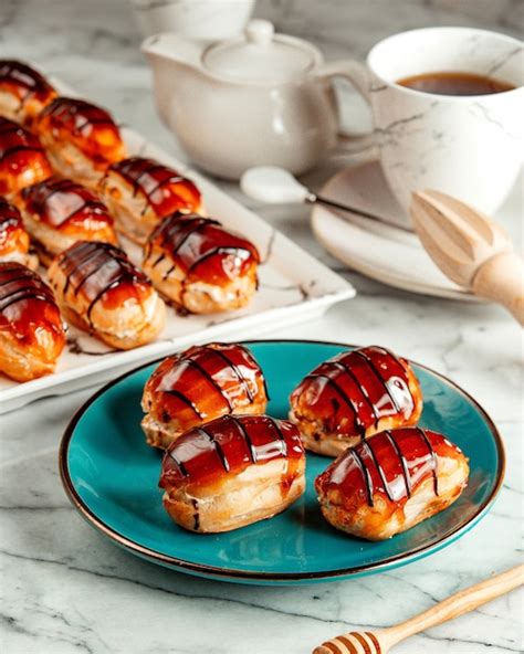 Free Photo Side View Of Small Eclair Covered With Caramel Served With Tea
