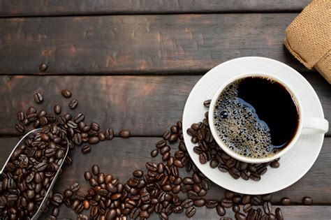 구운 커피 콩 대마 자루와 오래된 어두운 갈색 나무 테이블 배경 질감 상단보기에 특종 빈티지 흰색 색상 장식과 고전적인 커피