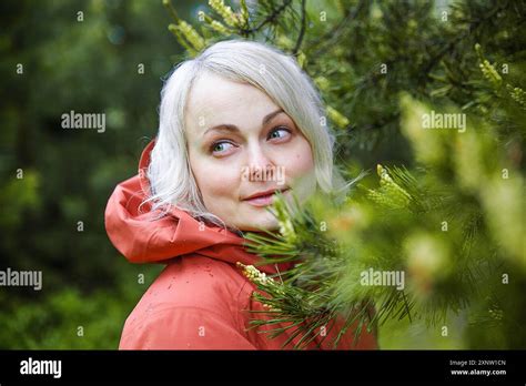 Beautiful Woman In A Corral Hooded Jacket In The Woods After The Rain Stock Photo Alamy