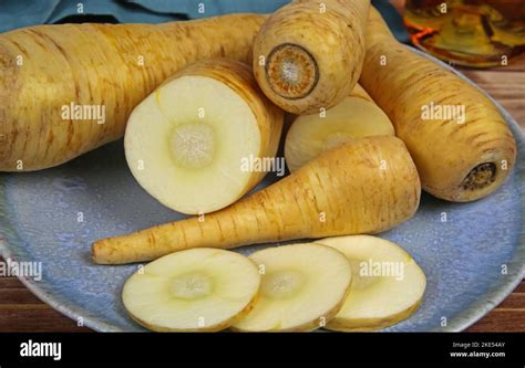 Closeup Of Group Many Raw Isolated Sliced Parsnip Root Vegetables On Blue China Plate Stock