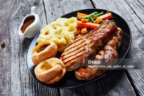 뼈에 구운 돼지 갈비 으깬 감자 녹색 콩 당근 요크셔 푸딩 양파 그레이비를 곁들인 잉글리시 선데이 로스트 0명에 대한 스톡 사진 및 기타 이미지 Istock