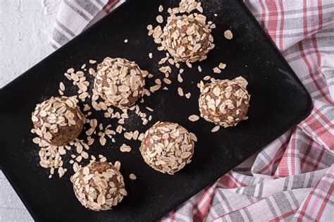 대추 귀리 플레이크 말린 크랜베리 피칸 너트로 만든 건강 한 유기농 에너지 볼은 흰색 바탕에 검정색 접시에 있습니다 0명에 대한 스톡 사진 및 기타 이미지 Istock