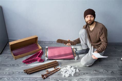 Bearded Man Is Trying To Assemble Furniture And Does Not Understand Instructions Stock Image