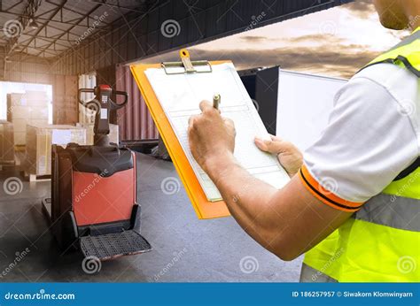 Warehouse Worker Holding Clipboard Checking On Checklist For Loading