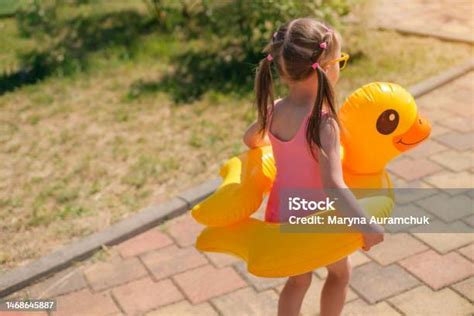 오리의 원을 가진 수영복을 입은 소녀는 수영하기 위해 호수로 해변으로가는 길에 간다 2 3 살에 대한 스톡 사진 및 기타 이미지 2 3 살 거리 걷기 Istock