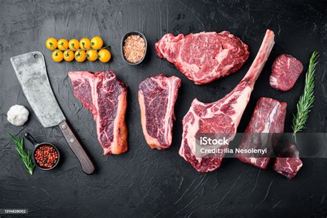 대리석 쇠고기 고기와 마른 숙성 스테이크 토마호크 T 뼈 클럽 스테이크 갈비뼈 와 부드러운 컷의 다양한 컷 검은 돌 배경에 상단