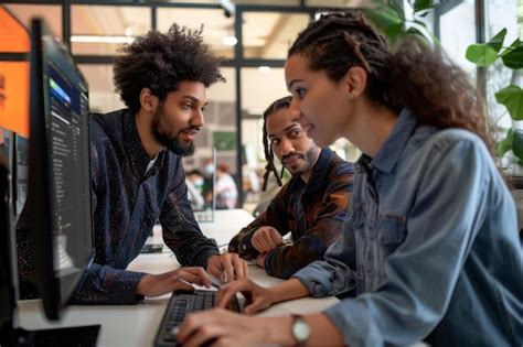 People Sitting Around A Computer Collaborating On A Software Project Collaborative Team Working