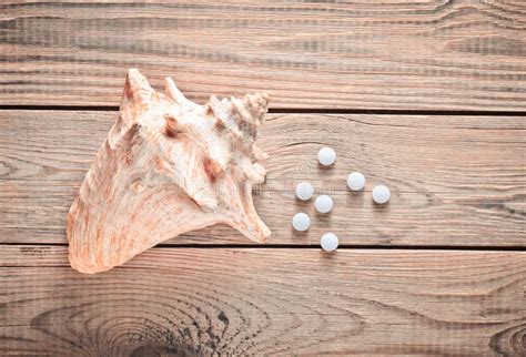 Tablets Of Calcium And Shell On A Wooden Table Medical Concept