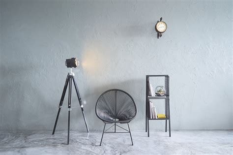 검은 여가 자 시계 녹색 식물 아이언 책장 및 램프 스탠드와 현대 거실 시멘트 바닥과 콘크리트 벽 로프트 스타일과 인테리어