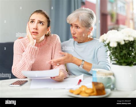 Worried Elderly Woman With Adult Daughter Checking Utility Bills Stock