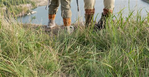 여행 중 산으로 둘러싸인 호수 앞에 서서 배낭을 손에 들고 있는 어린 엄마와 어린 아들의 뒷모습 사진 Unsplash의 복사