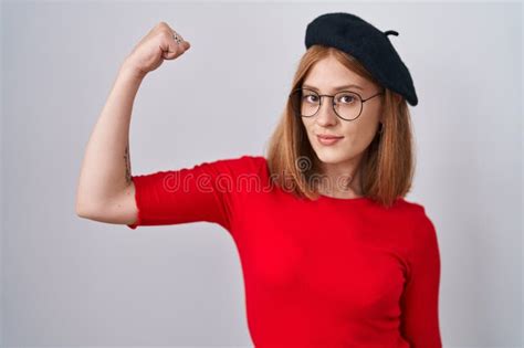 Young Redhead Woman Standing Wearing Glasses And Beret Strong Person