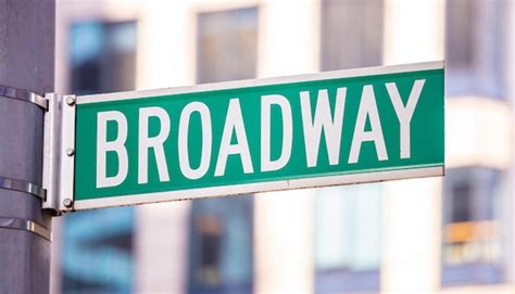 Premium Photo Broadway Road Sign Blur Buildings Facade Background