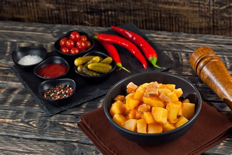 검은 그릇에 고기와 함께 삶은 감자 검은 색 나무 테이블에 조미료와 향신료 케첩 소금 오래된 초라한 배경에 후추 0명에 대한 스톡 사진 및 기타 이미지 Istock