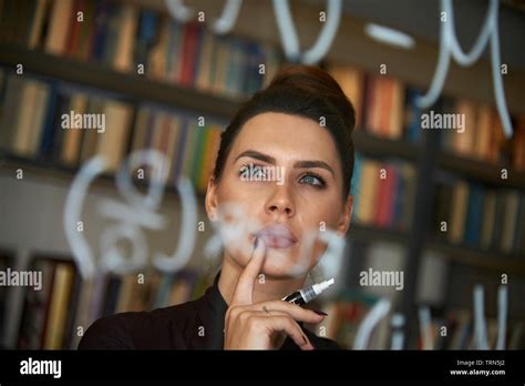 Female Computer Coder Writing Down A Complex Code On A Window At Her
