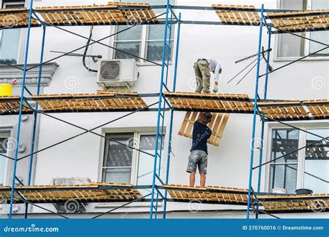 Building Facade Restoration Workers Are Assembling Scaffolding On A