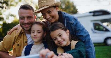야외에서 캐러밴과 함께 셀카를 찍는 두 자녀를 둔 행복한 젊은 가족 사진 Unsplash의 허리 위로 이미지