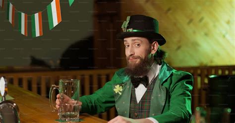 많은 맥주 레프러콘 의상을 입은 검은 머리 수염 난 청년이 즐거워 보인다 사진 Unsplash의 요정 이미지