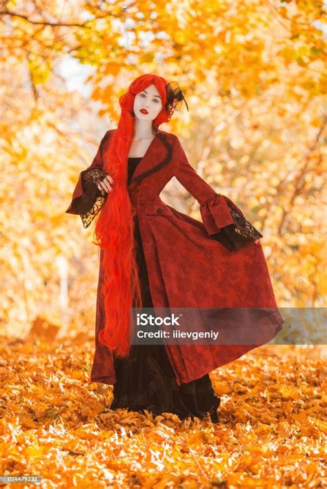 고딕 할로윈 코트입니다 가을 배경에 젊은 중세 여왕입니다 빨간 머리를 가진 여자 창백한 피부뱀파이어 할로윈을위한 중세 의상 고딕