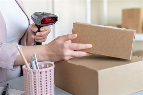 바코드 스캐너를 사용하여 소포를 스캔하는 운송 회사의 여성 직원이 고객 의 전송을 확인합니다 온라인 보내기 서비스 바코드