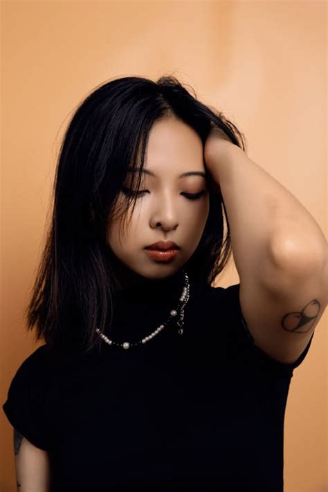 검은 머리 검은 상단 고정 머리 손 손 인간의 손 수직 쐈어 아름다운 여성 어두운 여성 포즈를 취하는에 관한 무료 스톡 사진