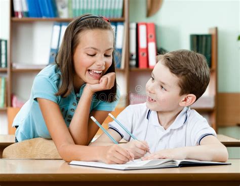 Ayudas De La Colegiala A Su Amigo Para Hacer La Tarea Foto De Archivo