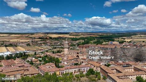 화창한 여름날 스페인의 주거용 건물의 갈색 타일 지붕에 대한 높은 고딕 양식의 종탑이있는 중세 로마 카톨릭 대성당의 아름다운 공중 전망 0명에 대한 스톡 사진 및 기타