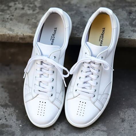 A Set Of Classic White Leather Tennis Shoes With Subtle Perforated