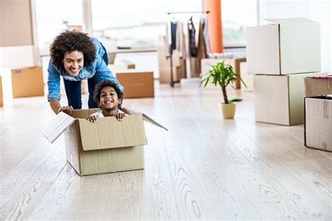 행복한 독신 흑인 어머니가 새 아파트에서 상자를 들고 딸을 밀어 내고 있습니다 가족에 대한 스톡 사진 및 기타 이미지 가족