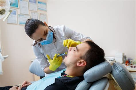 O Dentista Injeta O Paciente Na Gengiva Para Anestesiar Os Dentes