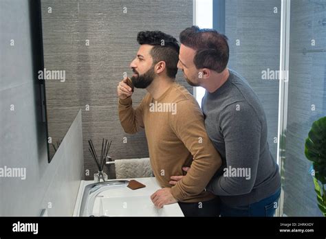 Closeup Of A Gay Married Hugging In The Bathroom Of Their Home Stock