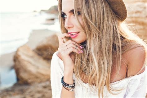 Close Up Portrait Of Attractive Blonde Girl With Long Hair On Deserted Beach She Wears White