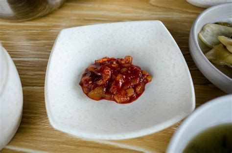 건강식품 고명 김치 도자기 접시 레스토랑 스타일 맛있는 매운 요리 목조 테이블 문화 요리 미식가 반찬 발효
