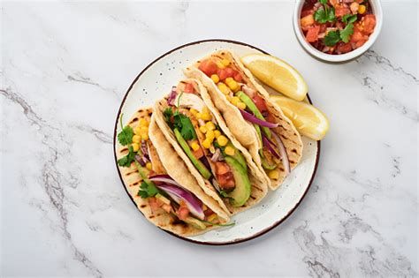 구운 닭고기 아보카도 옥수수 커널 토마토 양파 실란트로 살사를 곁들인 멕시코 타코 전통적인 멕시코 와 라틴 아메리카 길거리 음식 맨 위 보기입니다 거리에 대한 스톡 사진 및